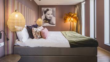 Quarto moderno com cama grande, decoração de parede estampada e uma janela ampla.