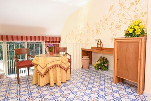 Quarto com uma mesa redonda, cadeiras, um armário e um detalhe decorativo na parede.