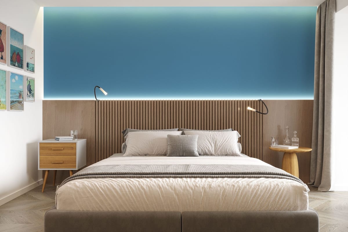 Quarto moderno com cama, mesas de cabeceira e uma luminária na parede.