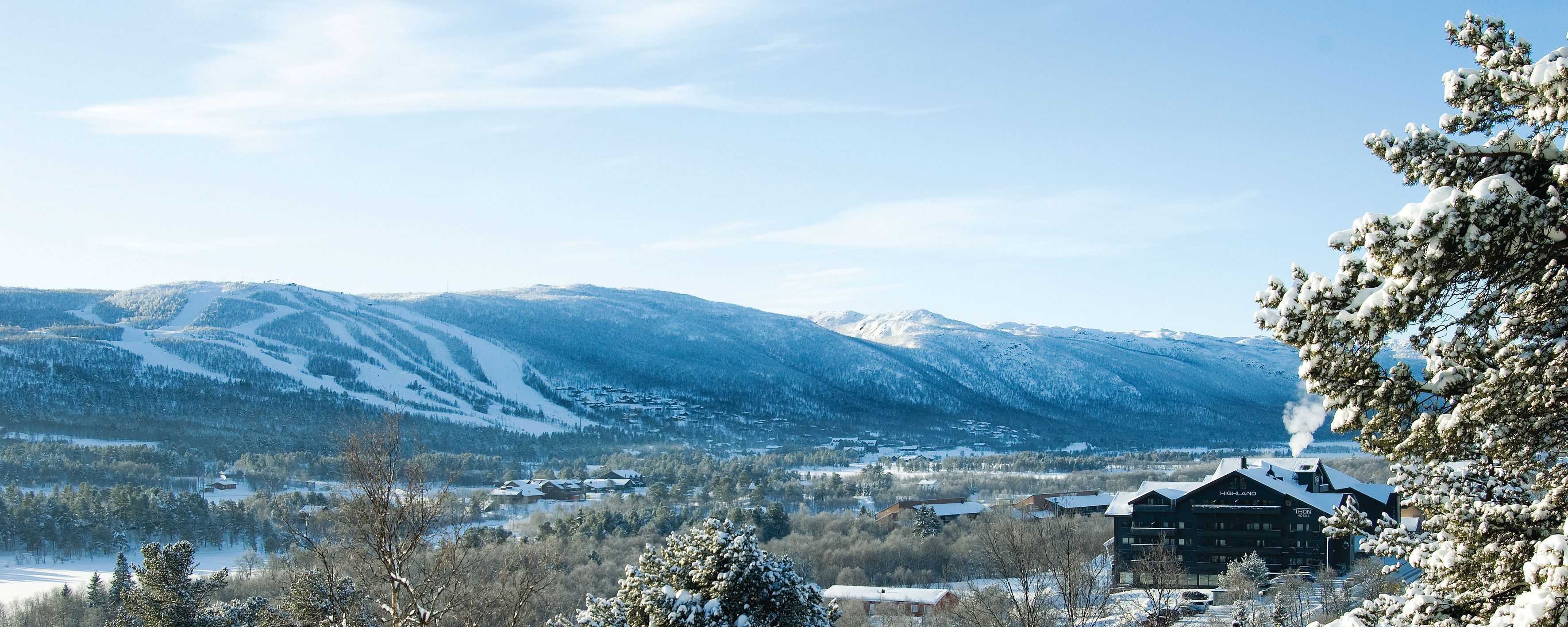 Uma pousada com vista para montanhas cobertas de neve e um vale.