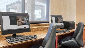 Uma secretária com dois monitores, um teclado e um rato.