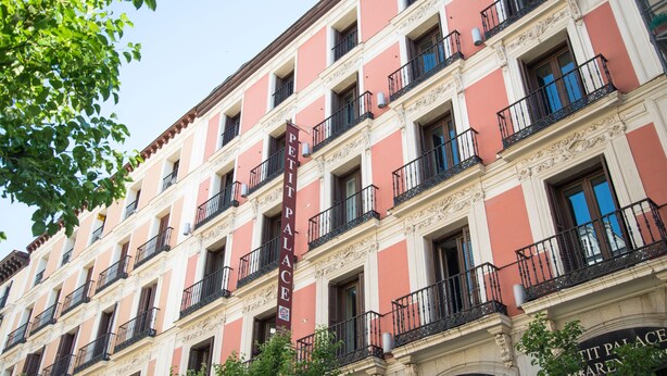 Um edifício com vários andares e varandas, com uma placa que diz 'PETIT PALACE'.