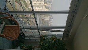 Vista de um prédio alto com vista para a paisagem urbana, incluindo um estacionamento e edifícios.
