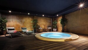 Uma área de piscina ao ar livre com aquecimento, espreguiçadeiras e plantas em vasos.