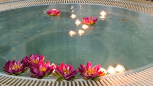 Uma banheira de spa com flores de lótus e velas.