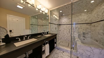 Uma casa de banho moderna com um espelho grande, duas pias, um chuveiro e uma banheira.