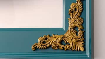 Uma porta emoldurada por tons de azul-esverdeado, com detalhes dourados ornamentais.