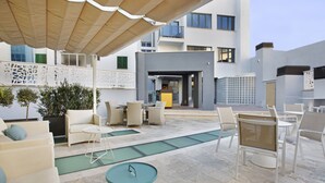 Uma área de estar ao ar livre com assentos e uma piscina.
