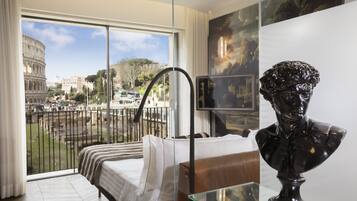 Quarto de hotel com uma cama, uma escultura de busto e vista para o Coliseu.