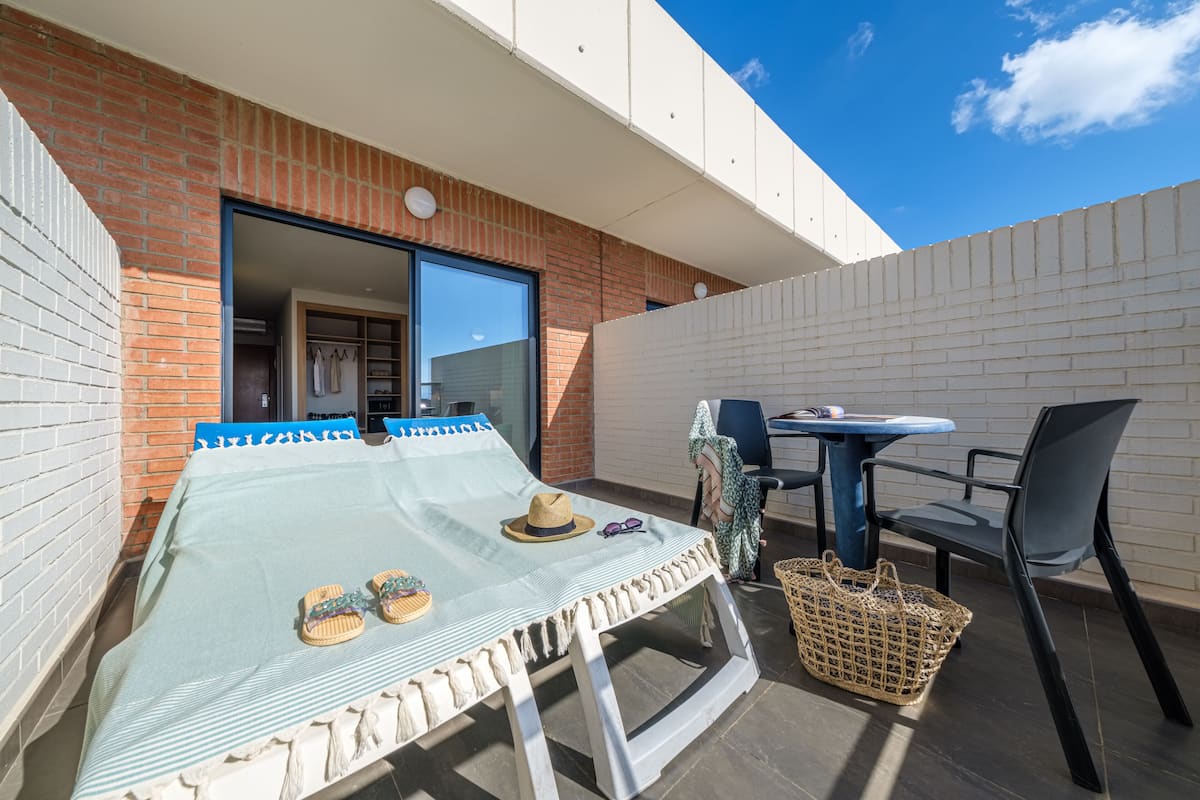 Terraço no telhado com mesa, cadeiras e cesto de vime.