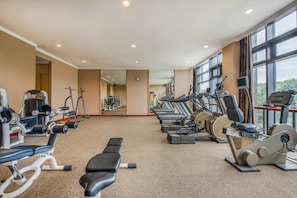 Uma academia com diversos equipamentos de exercício, incluindo esteiras, bicicletas ergométricas e aparelhos de musculação.
