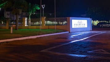 Vista noturna da entrada de um hotel com a placa 'Premier Hotel The Richards'.