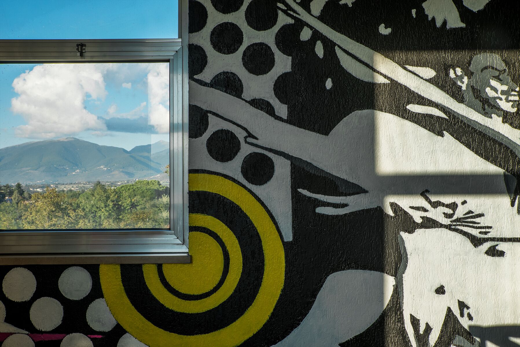 Janela com vista para uma montanha e paisagem urbana.