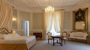 Um quarto amplo com uma cama grande, uma mesa de jantar e um sofá.
