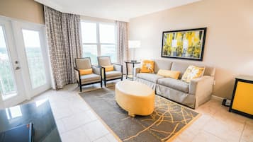 Uma sala de estar moderna com um sofá, poltronas, uma mesa de centro e um quadro na parede.
