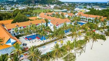 Um resort com vários edifícios, piscina e área de praia.