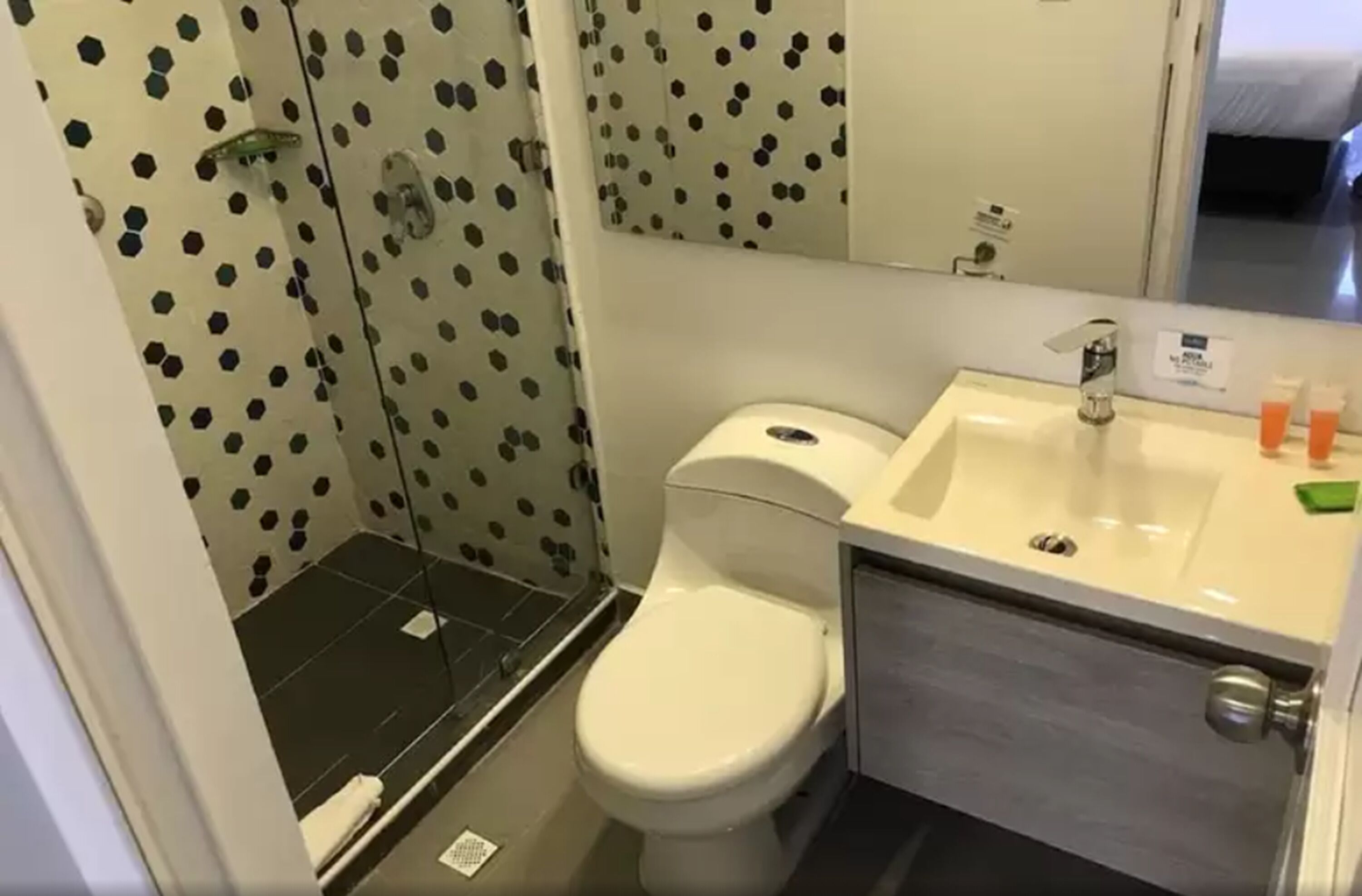 Uma casa de banho com chuveiro, sanita e lavatório.