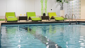 Uma área de piscina com espreguiçadeiras e uma planta de bambu.