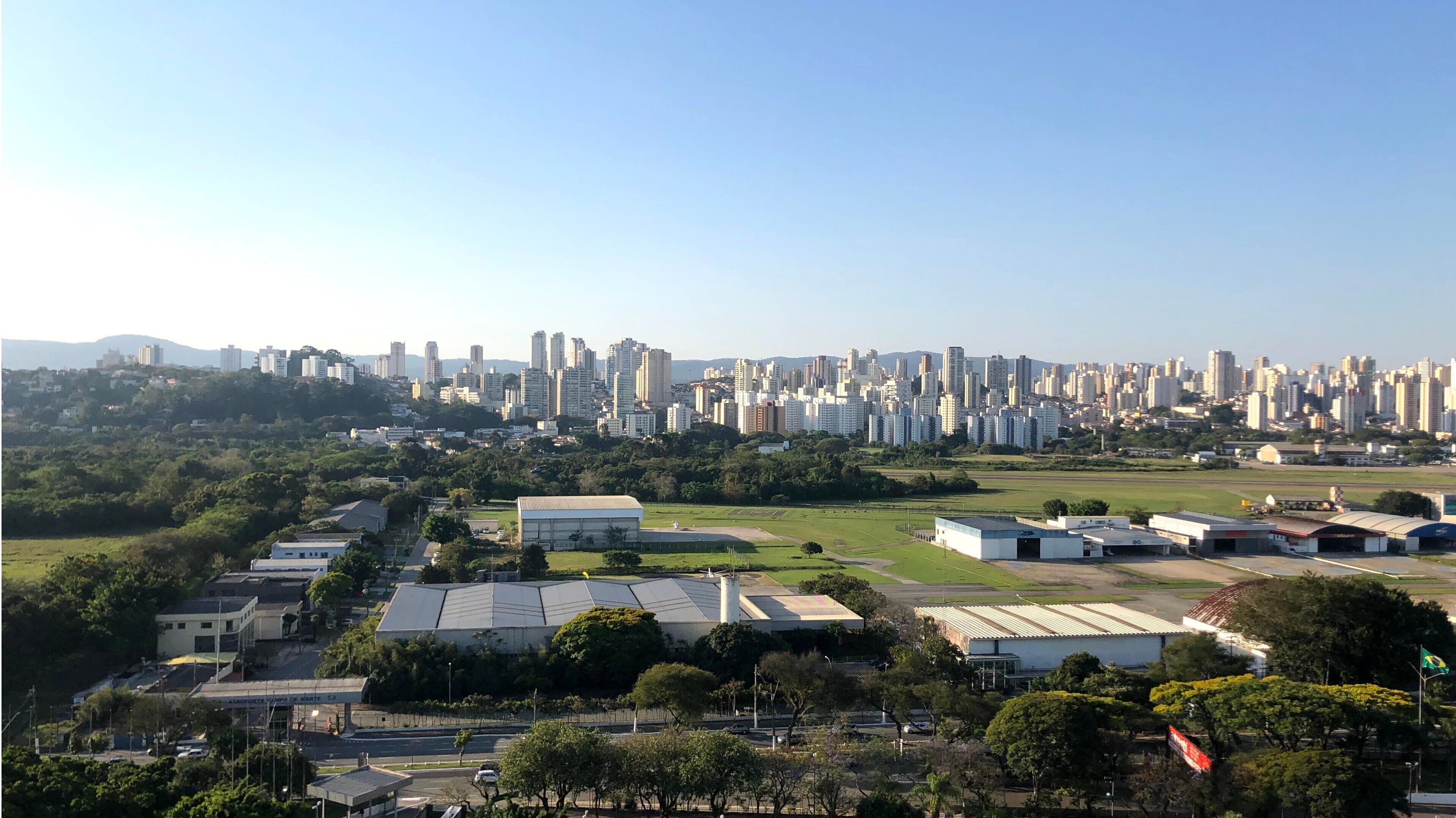 Paisagem urbana com arranha-céus, um grande espaço aberto e vários edifícios industriais.