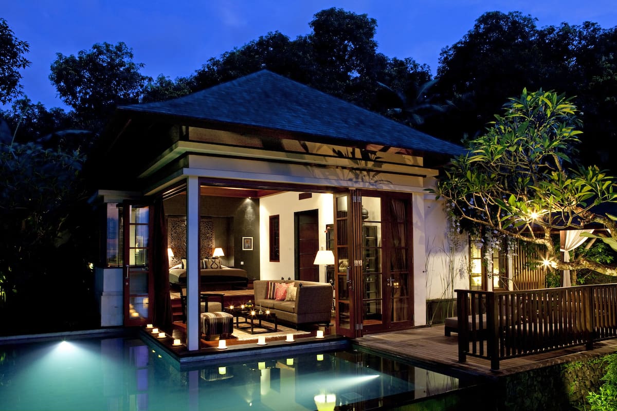 Uma villa moderna e bem iluminada, com piscina ao ar livre, sala de estar aconchegante e vegetação exuberante.