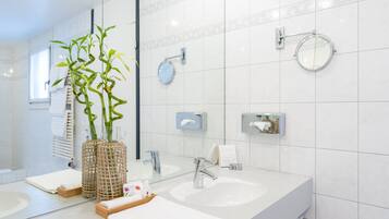Casa de banho moderna com duas lavatórios, um espelho grande e um porta-toalhas.