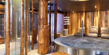 Sala de spa com hidromassagem, paredes de madeira e área de estar.
