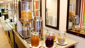 Disposição de buffet com diversos alimentos e recipientes.