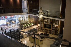 Um interior moderno com um sofá, cadeiras, uma TV e uma escada.