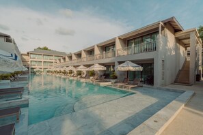 Um hotel moderno com piscina, área de estar ao ar livre e um edifício de vários andares.