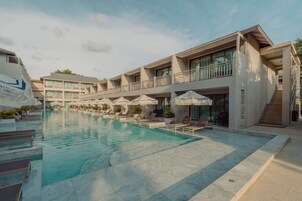 Um hotel moderno com piscina, área de estar ao ar livre e um edifício de vários andares.