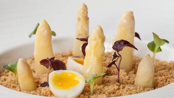 Prato com aspargos, ovo e vegetais sobre uma base esfarelada.
