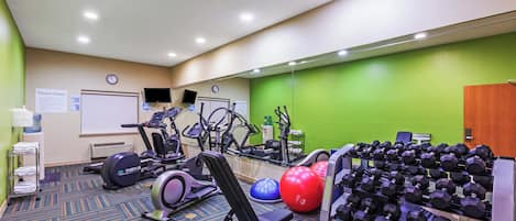 Centro de atividades físicas com equipamentos de ginástica, bebedouro e relógio na parede.
