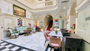 Uma sala de jantar ampla com piso xadrez, mobiliário elegante e uma varanda com grade.