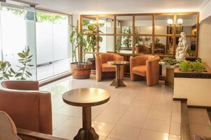 Decoração moderna com área de estar, plantas em vasos e uma estátua.