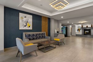 Um hall moderno com um sofá, poltronas e uma mesa de centro.