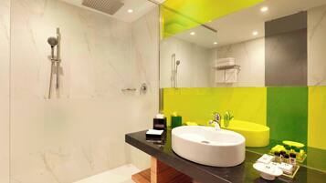 Um banheiro moderno com chuveiro de mármore, pia branca e banheira amarela.