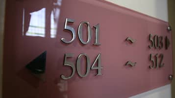 Placa metálica com os números dos quartos 501, 502, 503 e 504, indicando a atribuição de quartos no hotel.