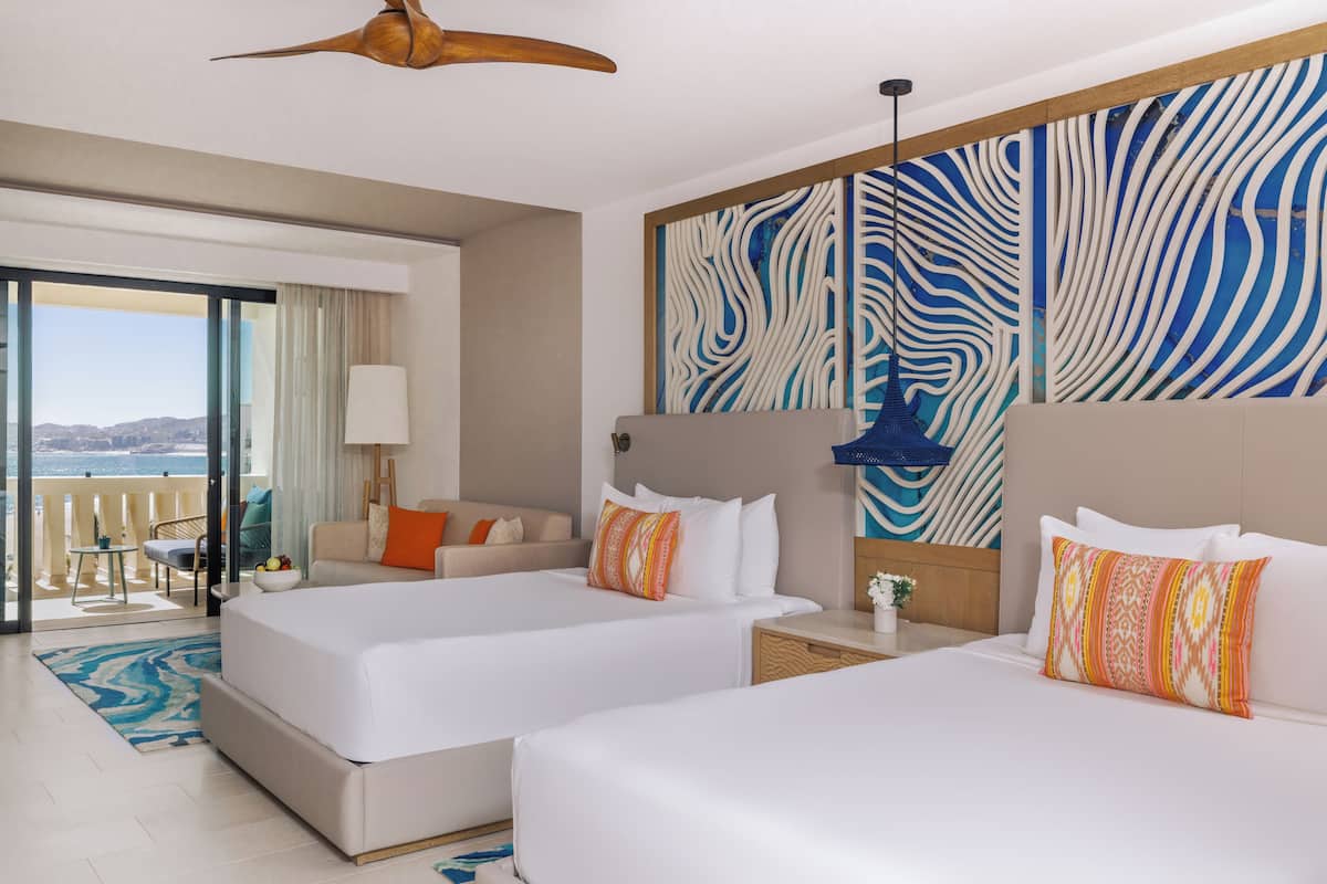 Quarto de hotel com duas camas, varanda com vista e uma grande obra de arte abstrata na parede.