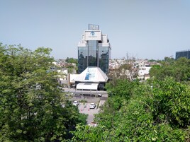 Um edifício moderno com fachada de vidro e uma placa com a inscrição "THE MAYA".