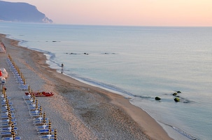 Praia particular, espreguiçadeiras, guarda-sóis