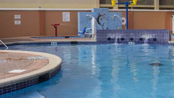 Piscina com mural de golfinho, um elemento aquático e posto de salva-vidas.