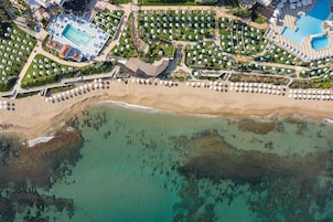 Na praia, espreguiçadeiras, guarda-sóis, toalhas de praia