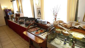 Uma mesa de buffet com diversos alimentos e acompanhamentos.