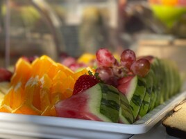 Uma tábua de frutas com melancia, morangos e uvas.