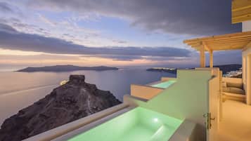 Uma área de spa com vista para o mar e uma ilha rochosa.