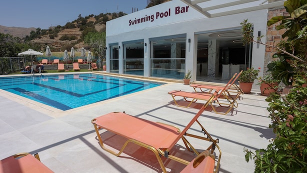 Bar à beira da piscina com espreguiçadeiras e piscina.