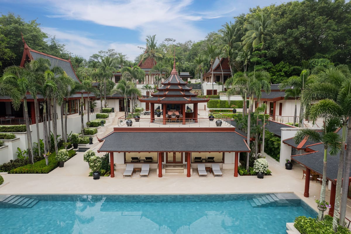 Um resort com piscina central, vários quartos de hóspedes e uma estrutura em estilo pagoda.
