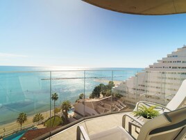 Varanda com vista para o mar e um edifício de resort.