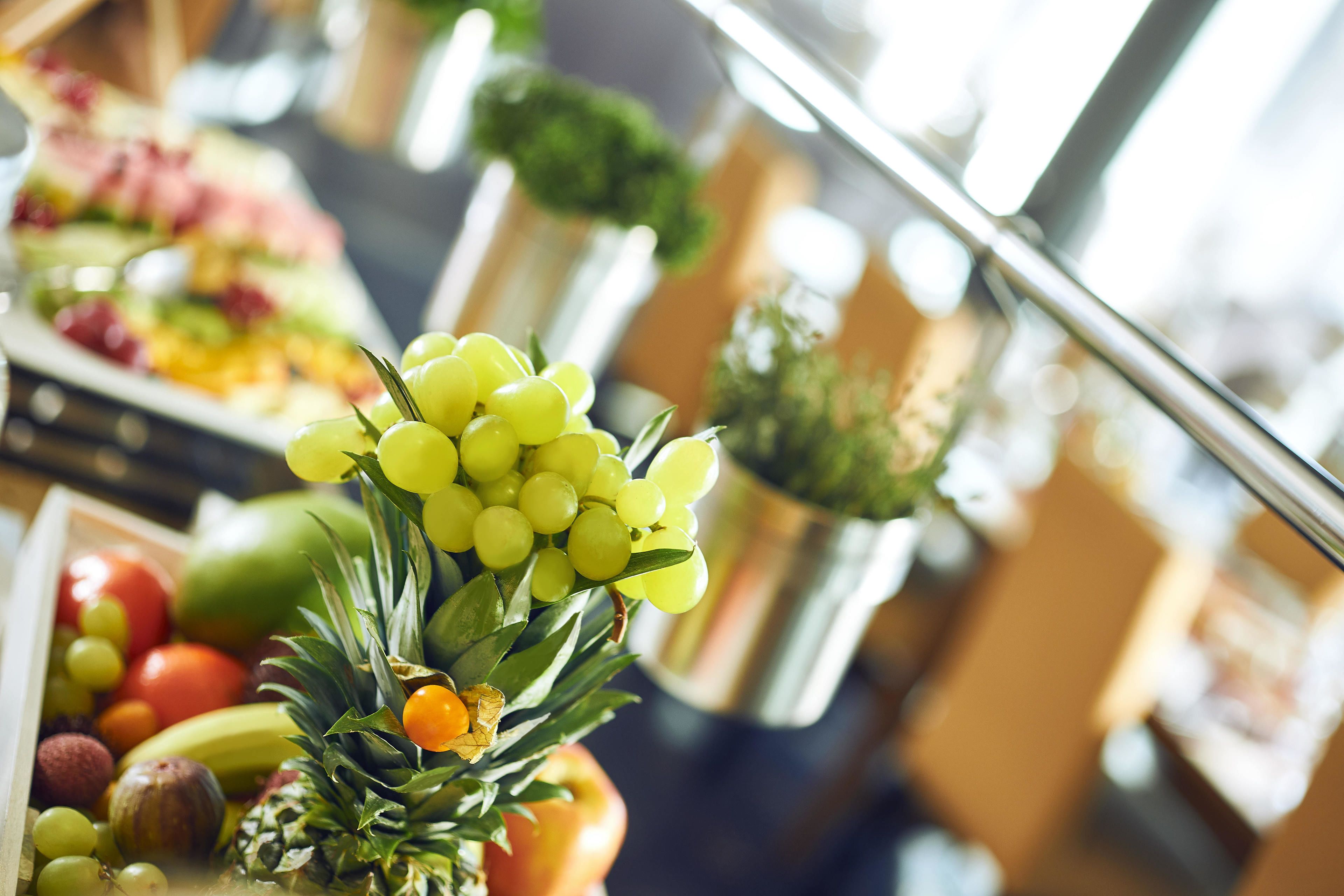 Exposição de frutas com uvas, abacaxi e outras frutas.
