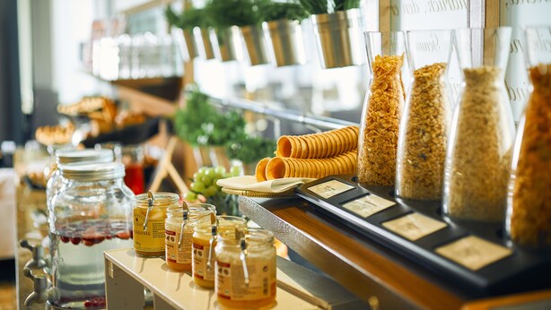 Um buffet de café da manhã com diversos alimentos e acompanhamentos.